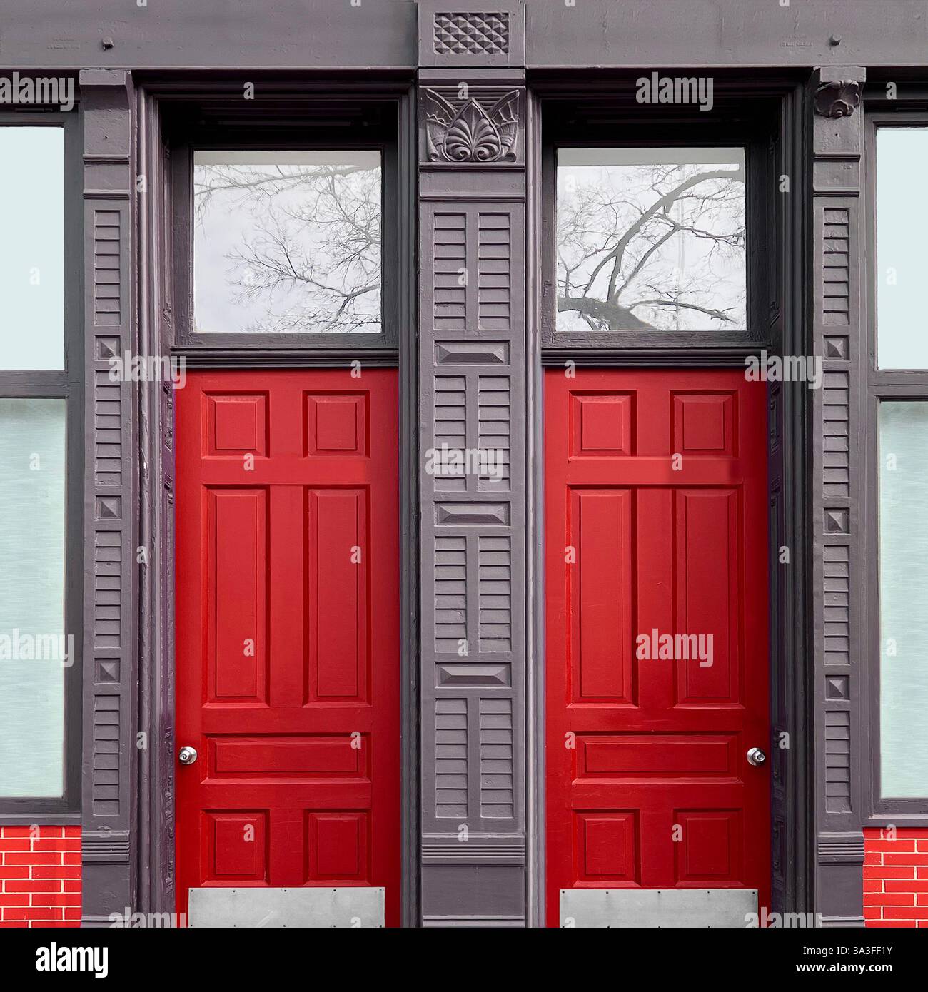 Architectural façade featuring double red doors framed by intricate ...