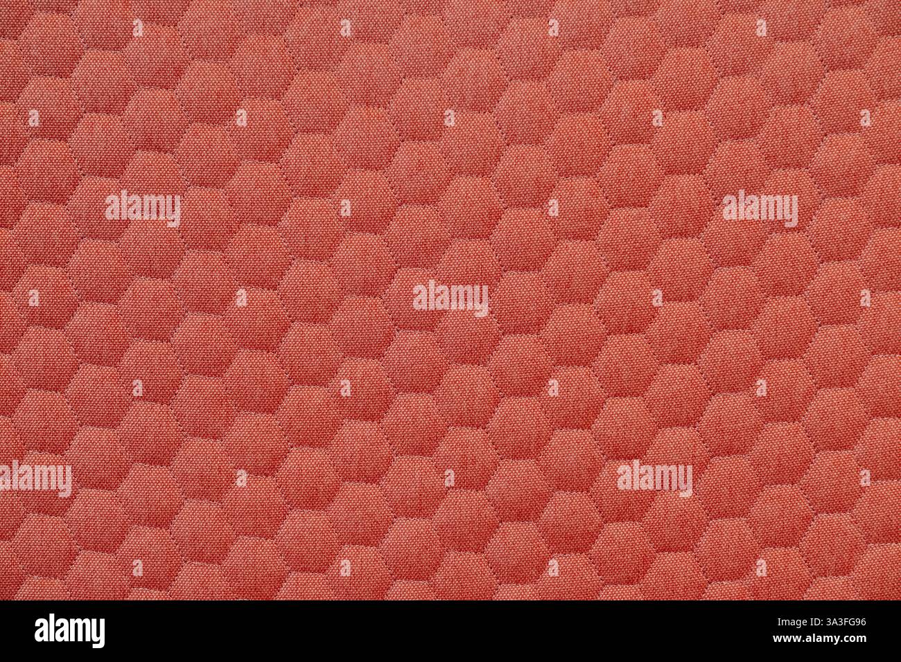 Detailed view of a coral colored fabric texture featuring a repeating ...