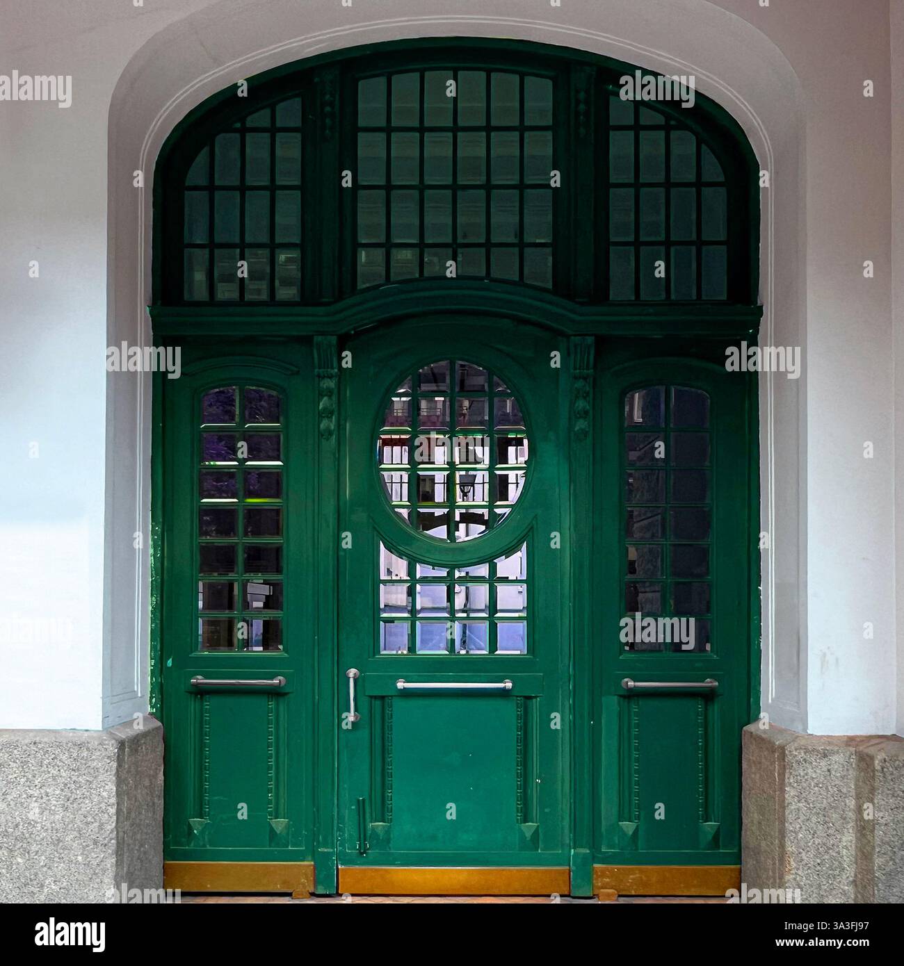 An elegant green gate with intricate glass paneling and an arched ...