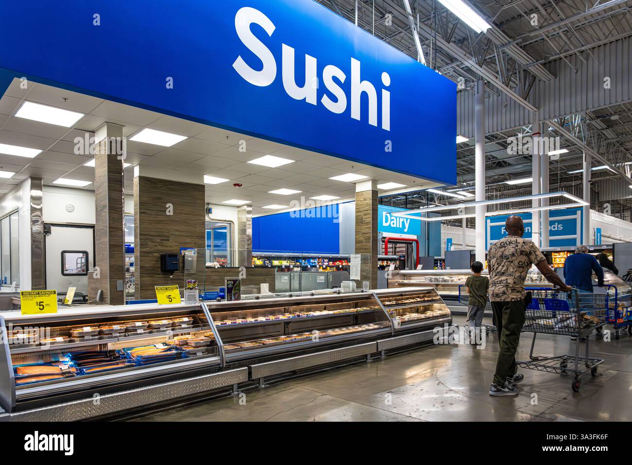 Shoppers stroll by the seafood department at Sam's Club membership ...