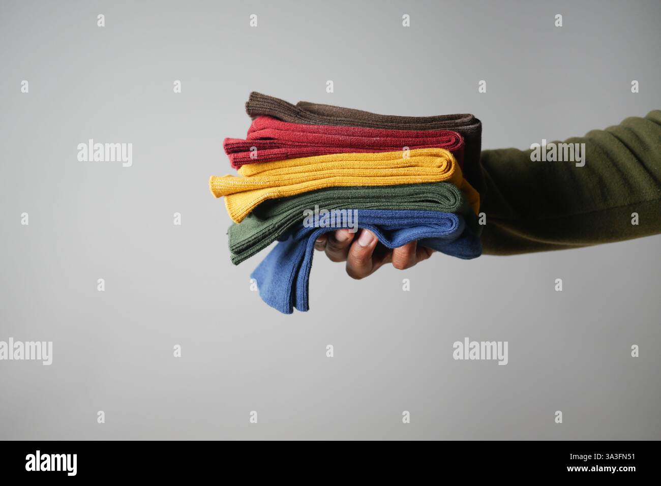 Colorful stack of freshly folded socks held in a hand Stock Photo - Alamy