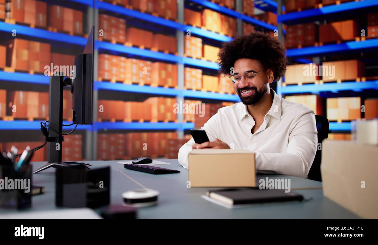 Black African man with phone scanning barcodes in small warehouse Stock ...