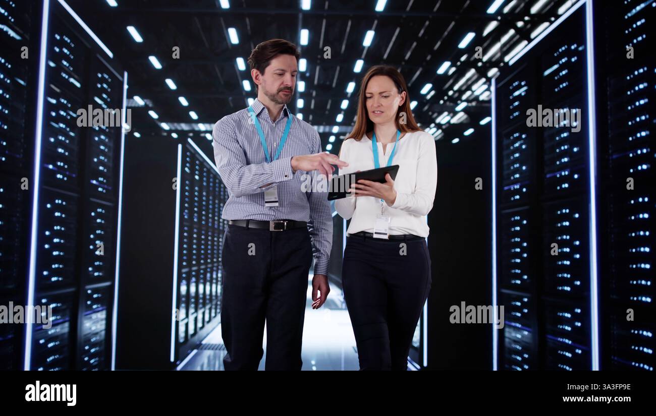 Engineers in data center server room configuring AI technology ...