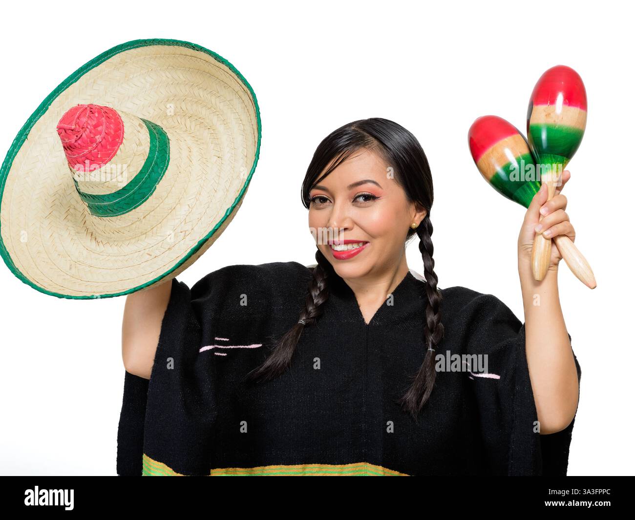 Smiling Mexican woman wearing colorful poncho and hat plays maracas ...