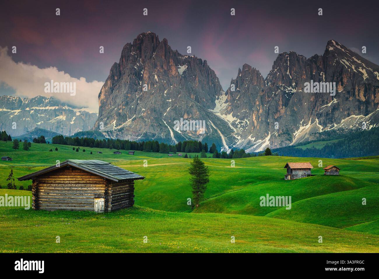 Amazing summer landscape with small cute wooden huts on the green field ...