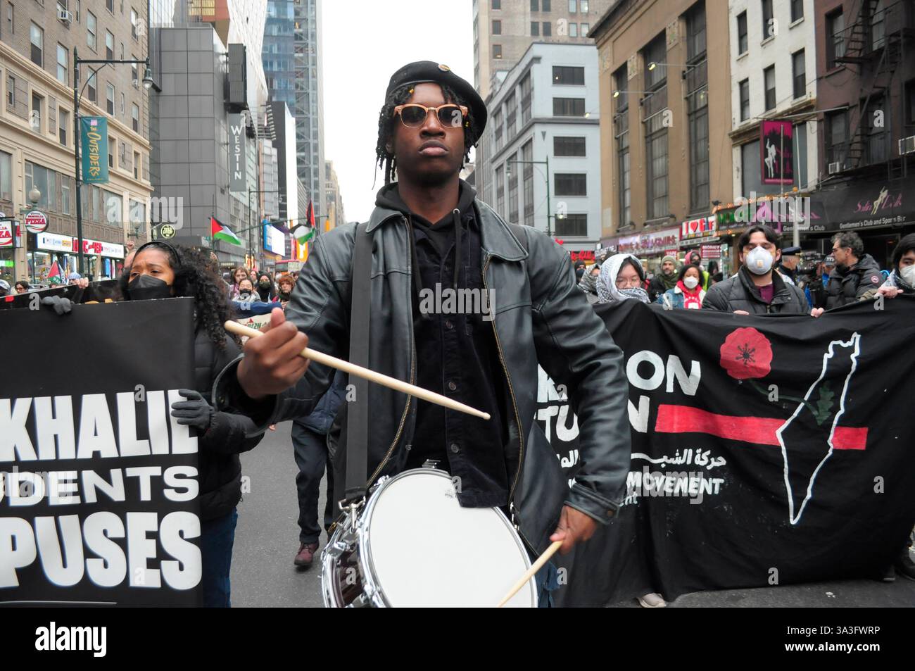 A pro-Palestine demonstrator marches while playing the drum ...