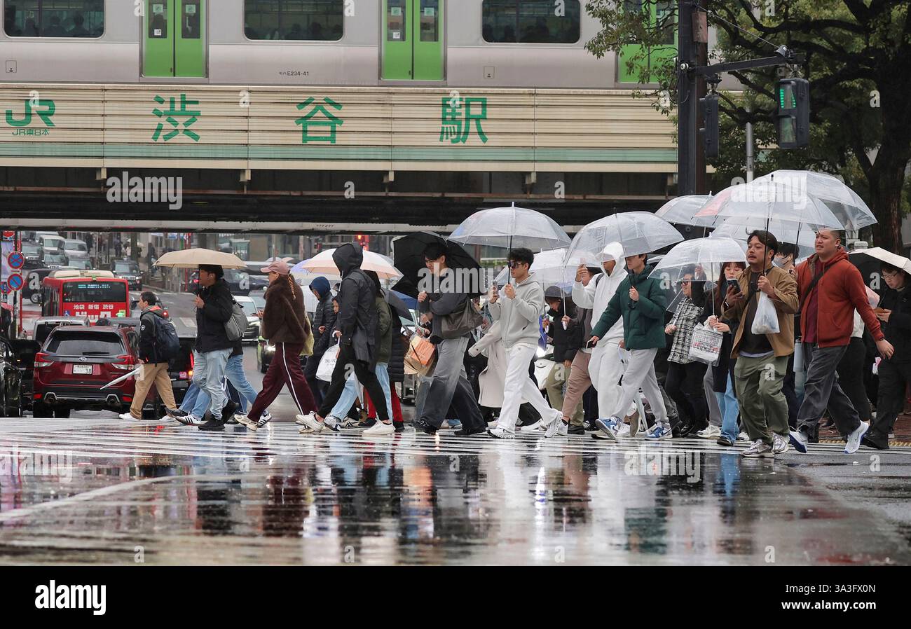 People walk with umbrella in cold rain near JR Shibuya station in ...