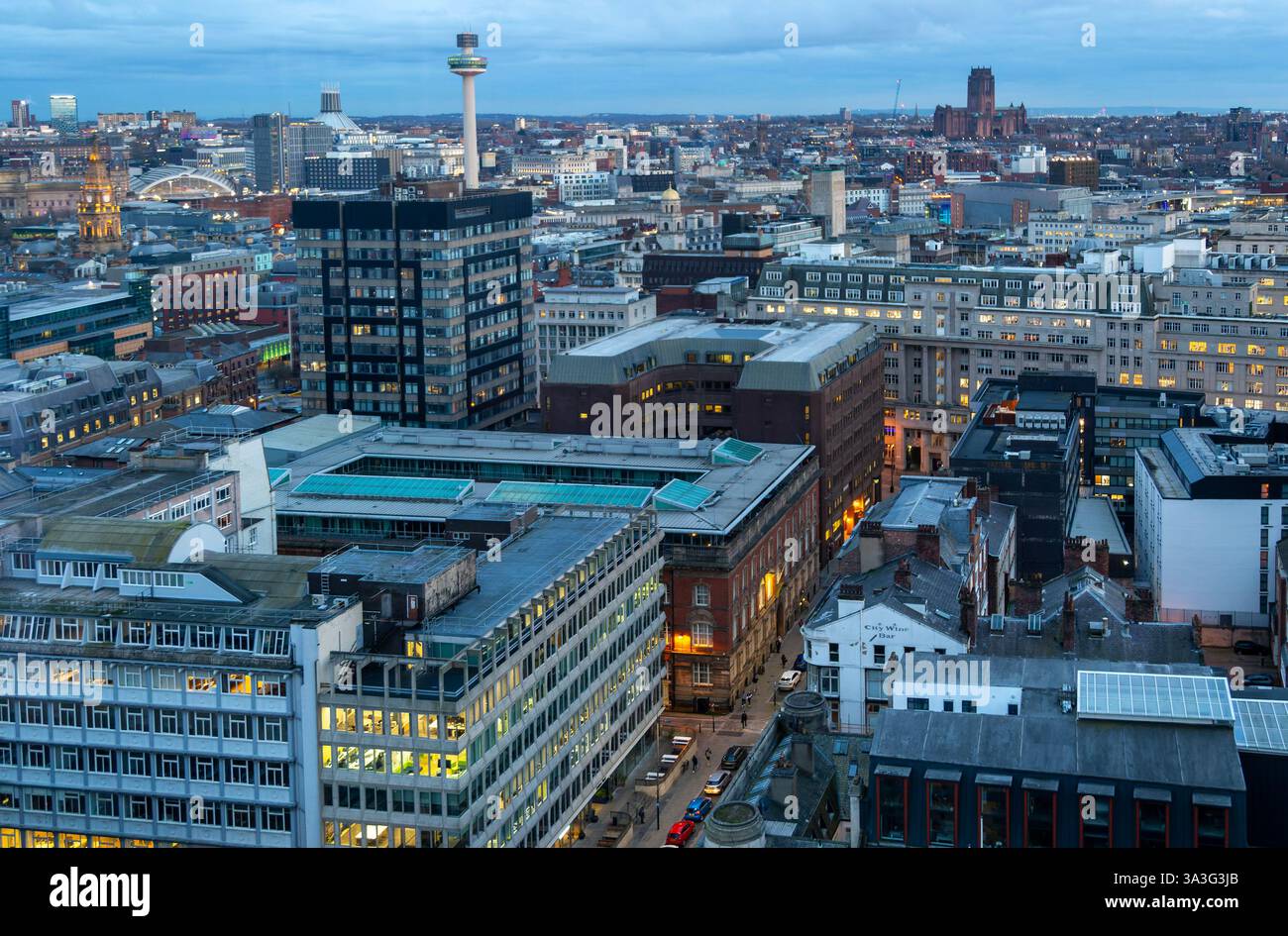 Nighttime view over city centre rooftops office blocks illuminated by ...
