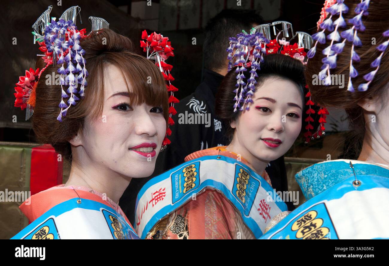 Two women dressed as maiko (apprentice geisha) with white face makeup ...