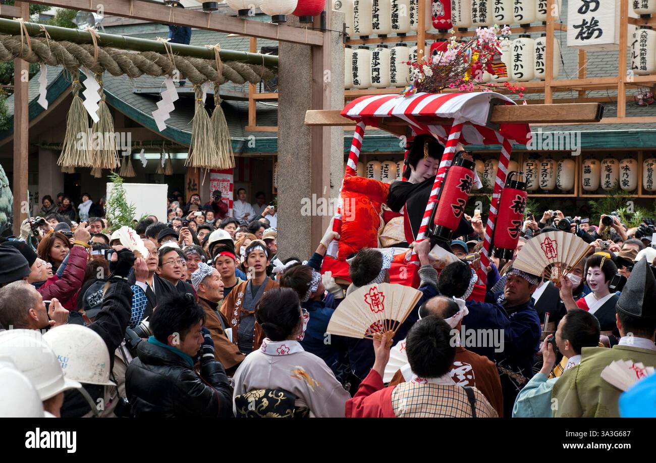 Geisha riding inside a traditional palanquin is jostled about above a ...