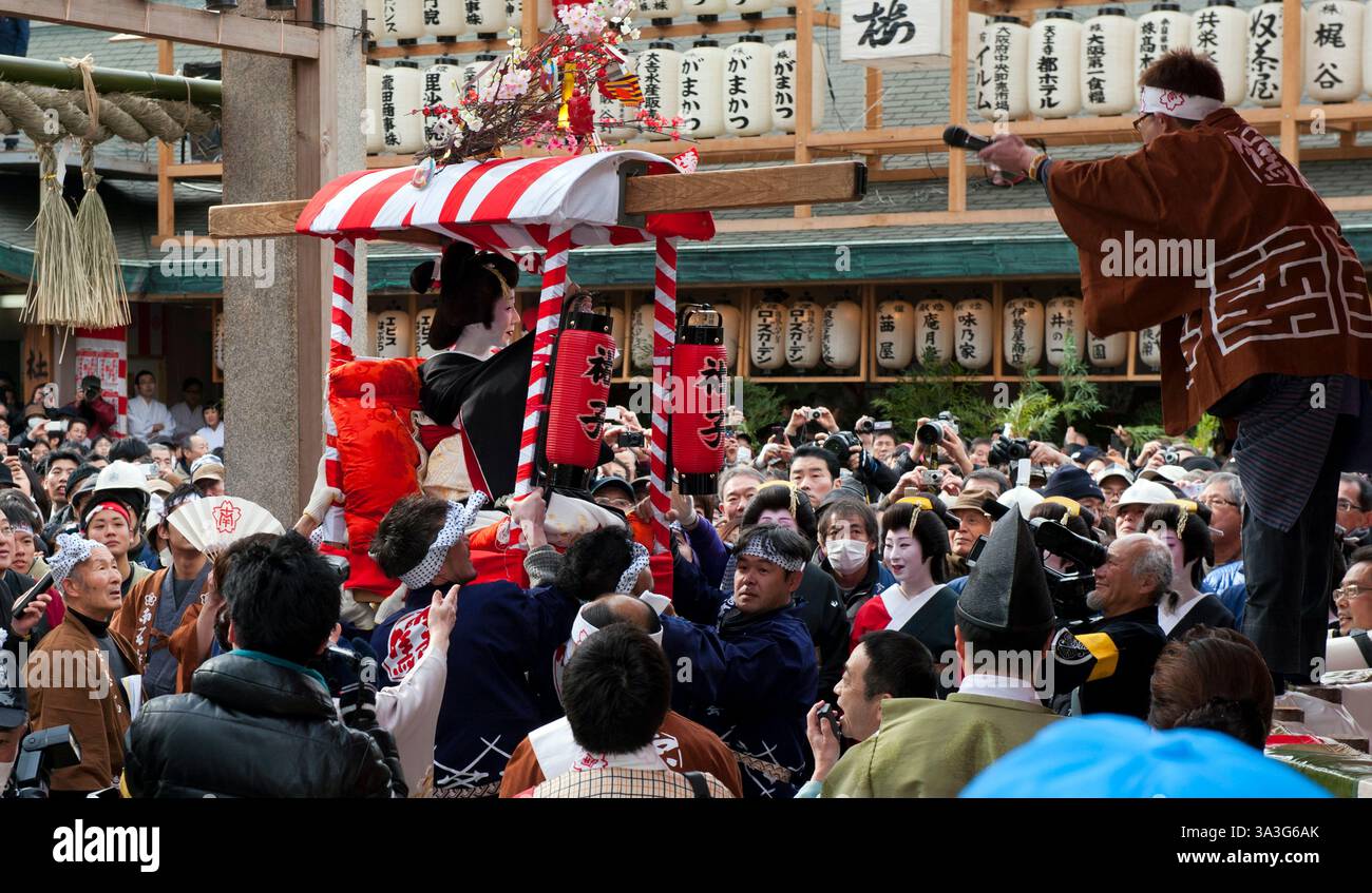 Geisha riding inside a traditional palanquin is jostled about above a ...