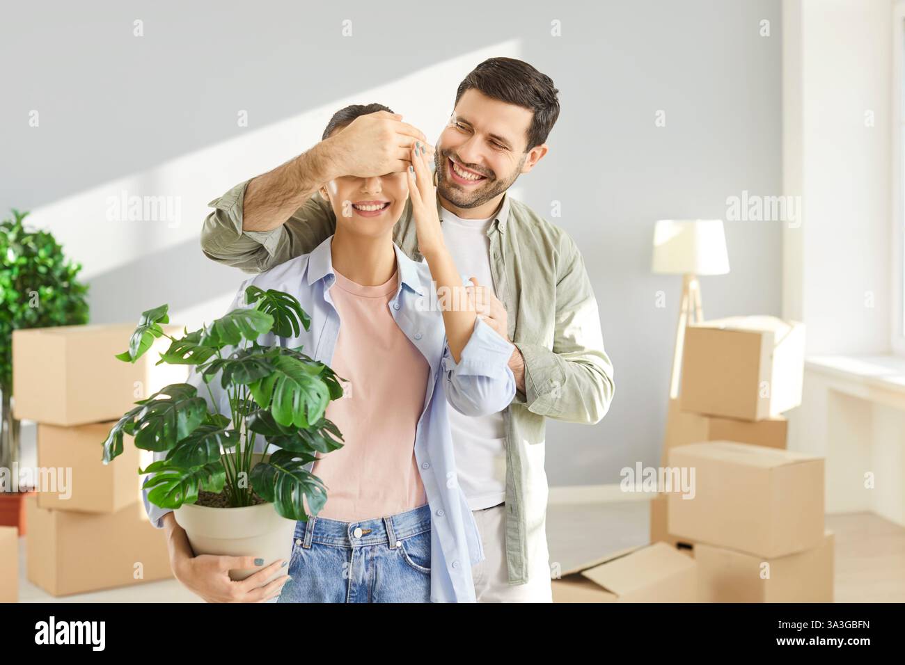 Moving day surprise, excited man covering woman eyes with hand ...