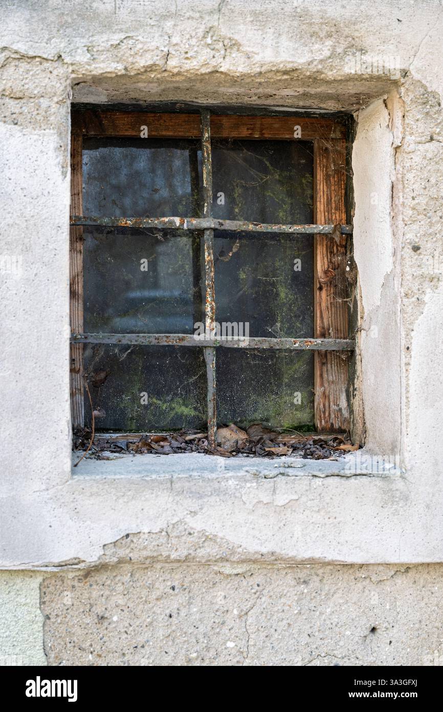 A weathered window, framed by crumbling concrete, hints at forgotten ...