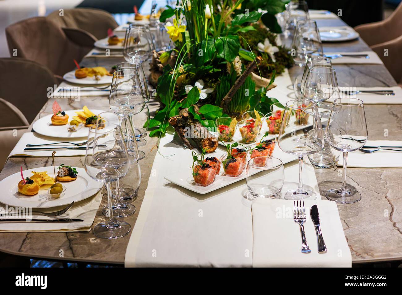Luxurious dining table setup featuring gourmet appetizers, elegant glassware, floral centerpiece ...