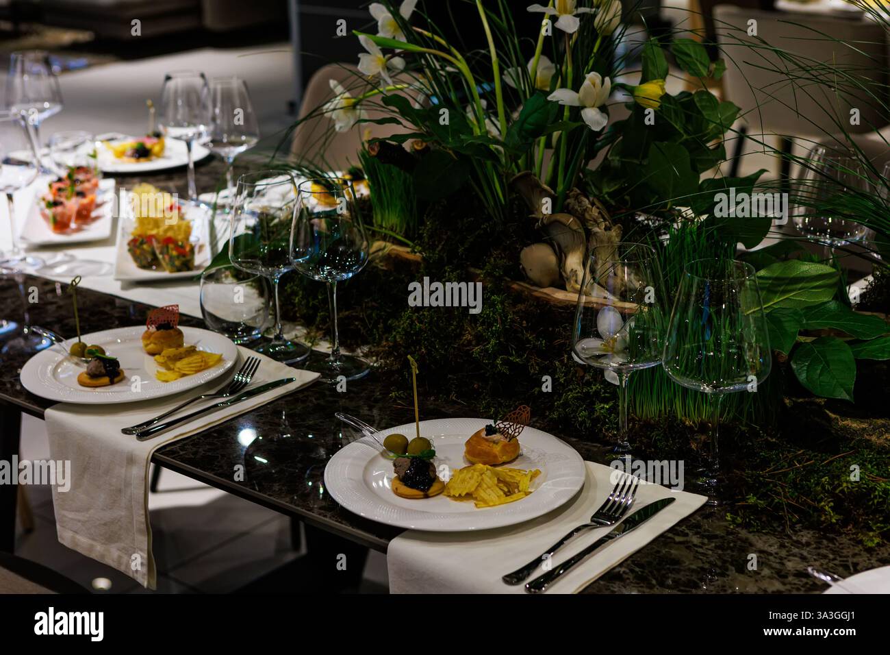 Luxurious dining table setup featuring gourmet appetizers, elegant glassware, floral centerpiece ...