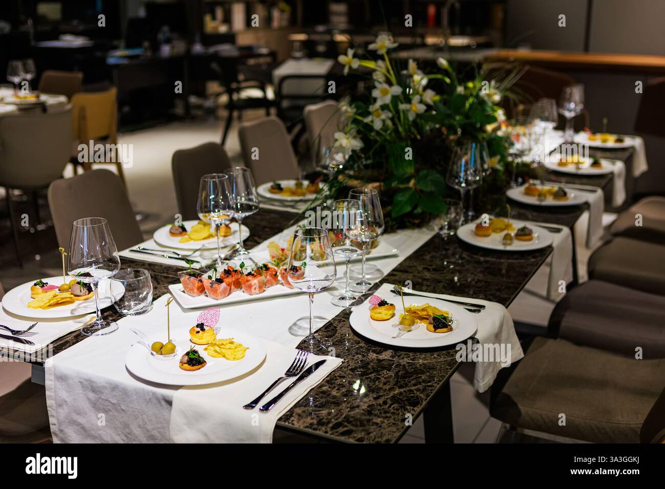 Luxurious dining table setup featuring gourmet appetizers, elegant glassware, floral centerpiece ...