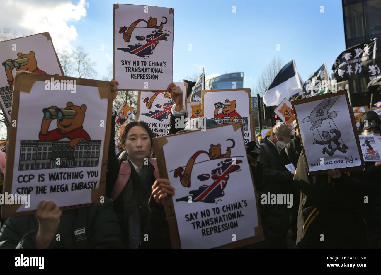 A protester among a sea of signs holds a sign saying ‘Say No To China’s ...