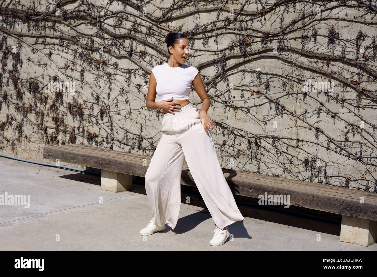 A dynamic dance pose against a vibrant wall backdrop, showcasing ...