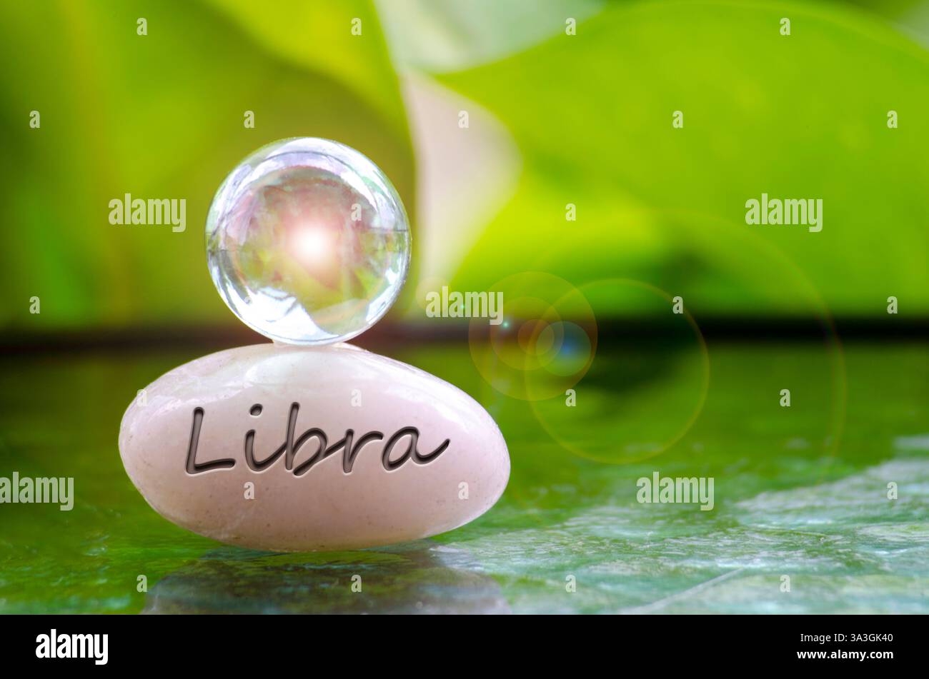 Libra text engraved on Zen stone with shining glass marble on top ...