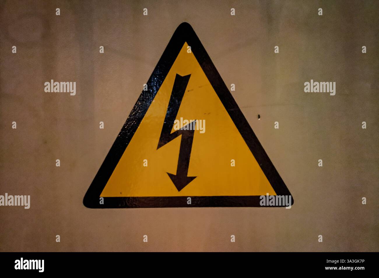 A close-up of a yellow and black high voltage warning sign with a ...