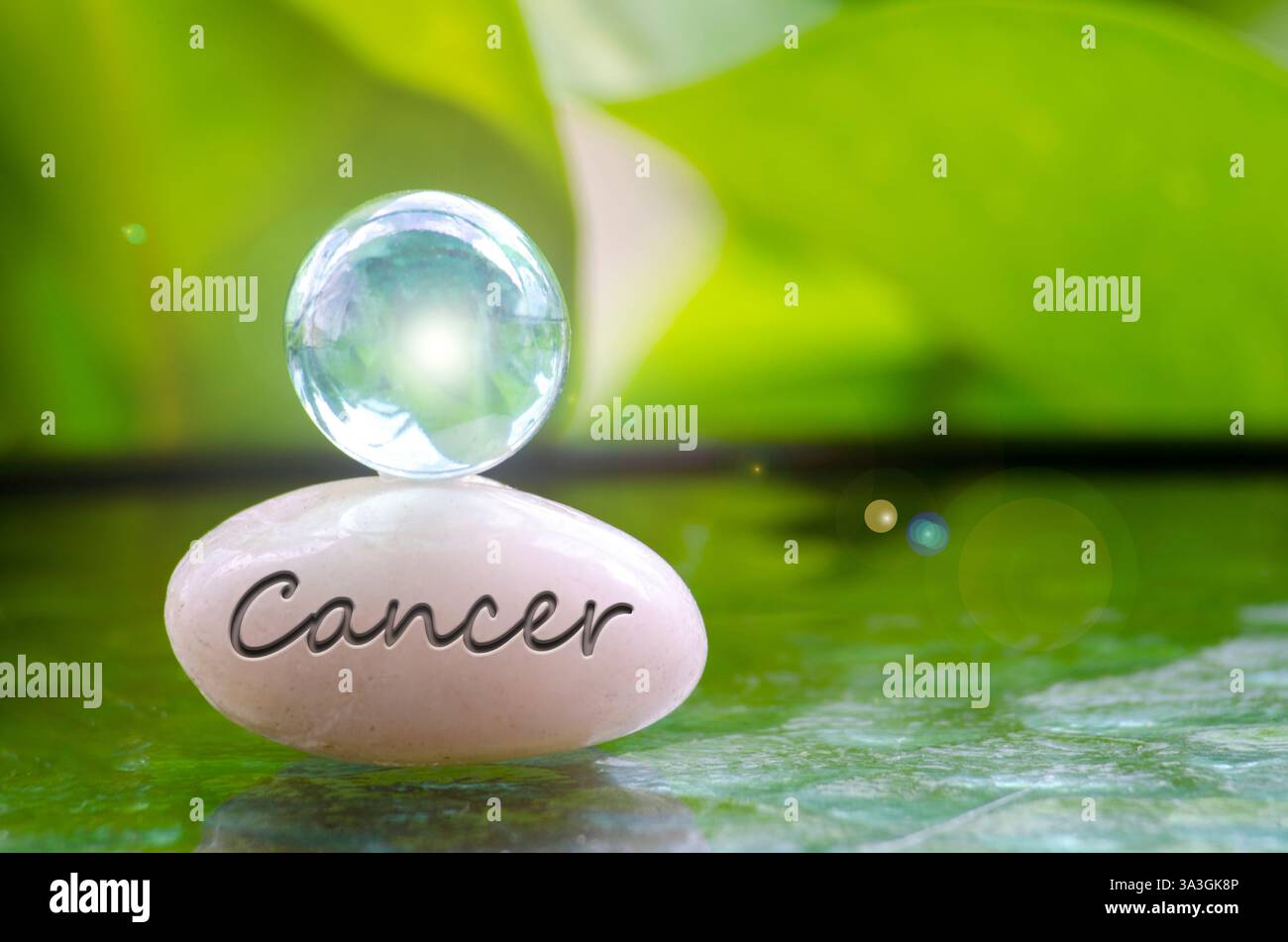 Cancer text engraved on Zen stone with shining glass marble on top ...