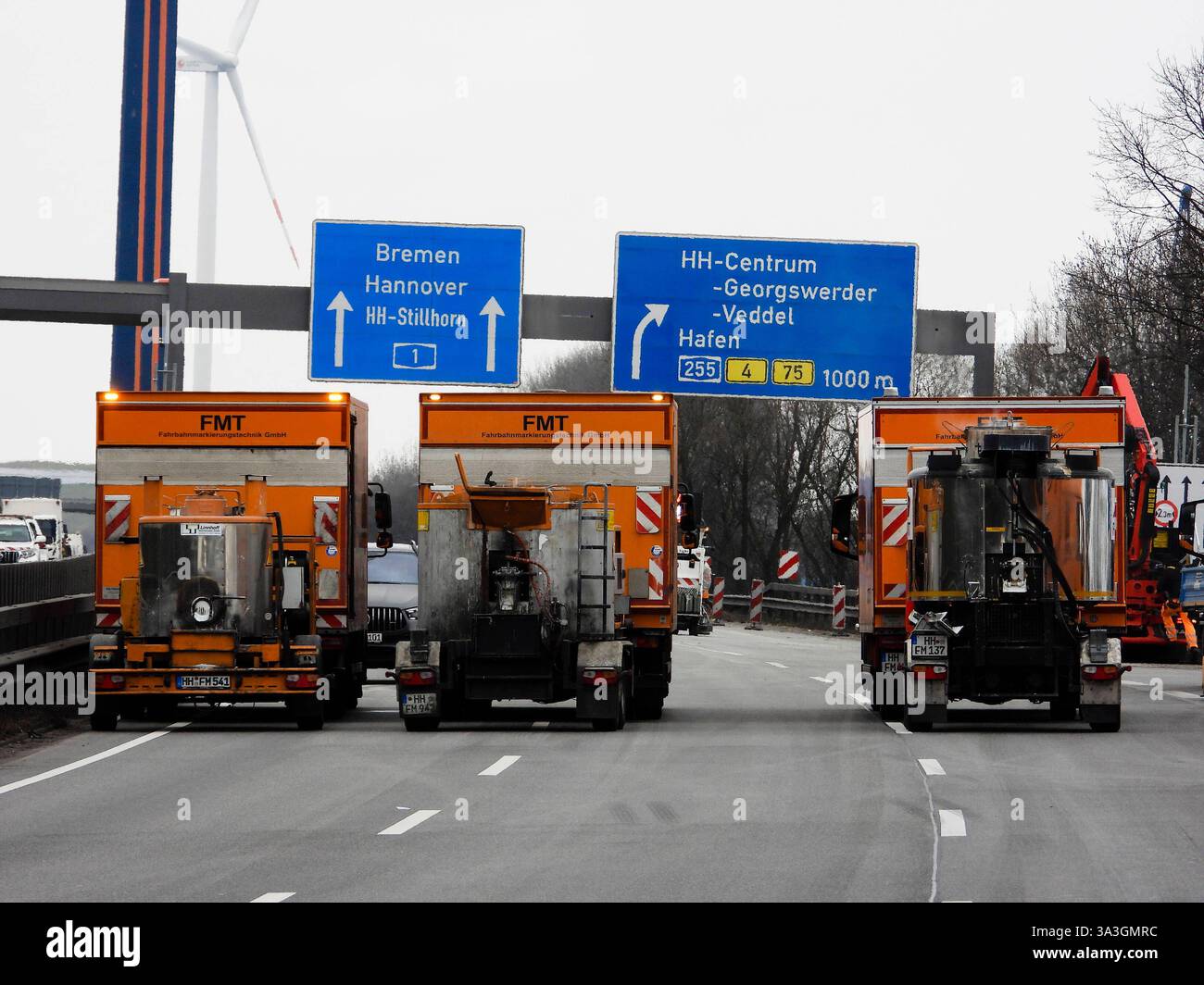 Strassenbauatbeiter der Firma FTM in Orangener Schutzkleidung bringen ...
