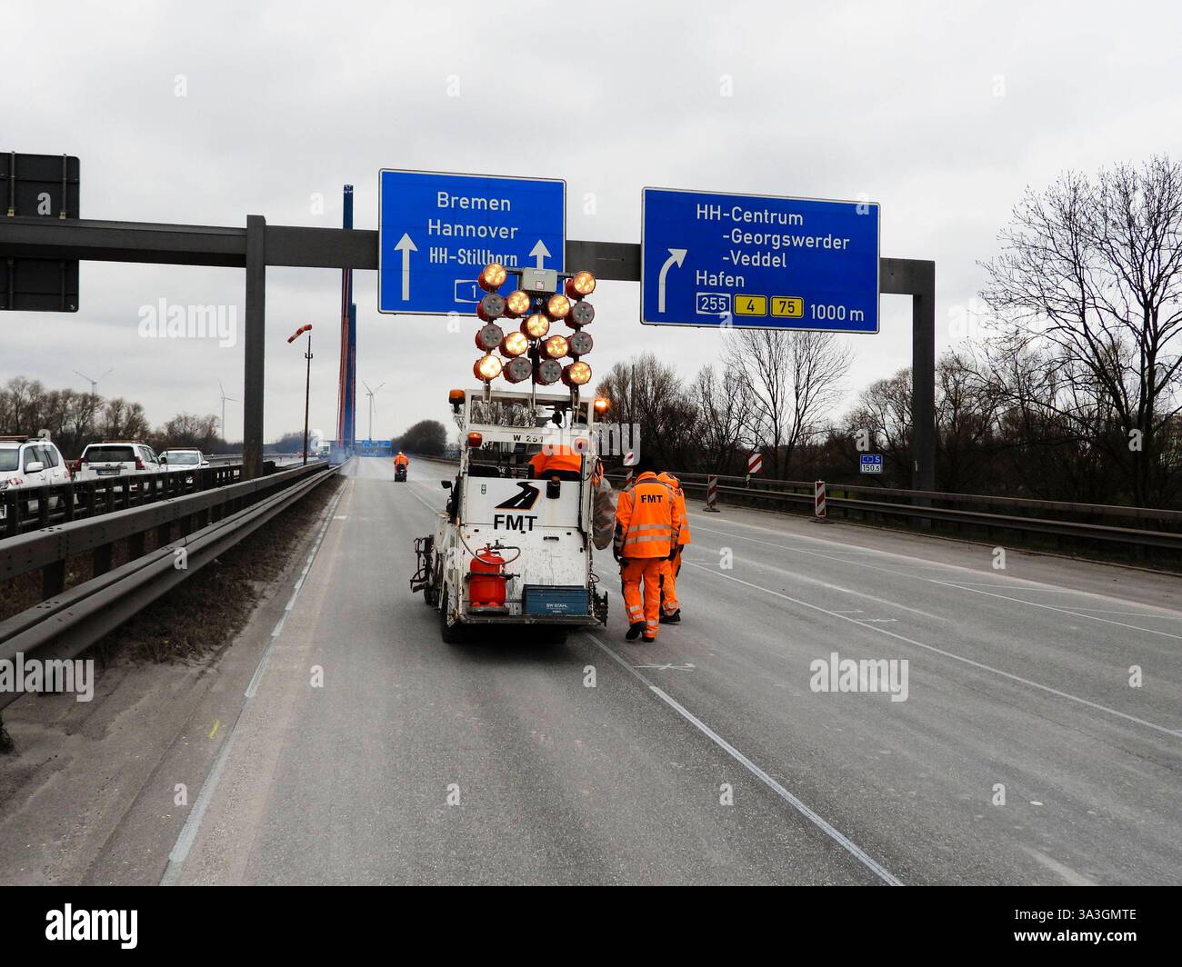 Strassenbauatbeiter der Firma FTM in Orangener Schutzkleidung bringen ...