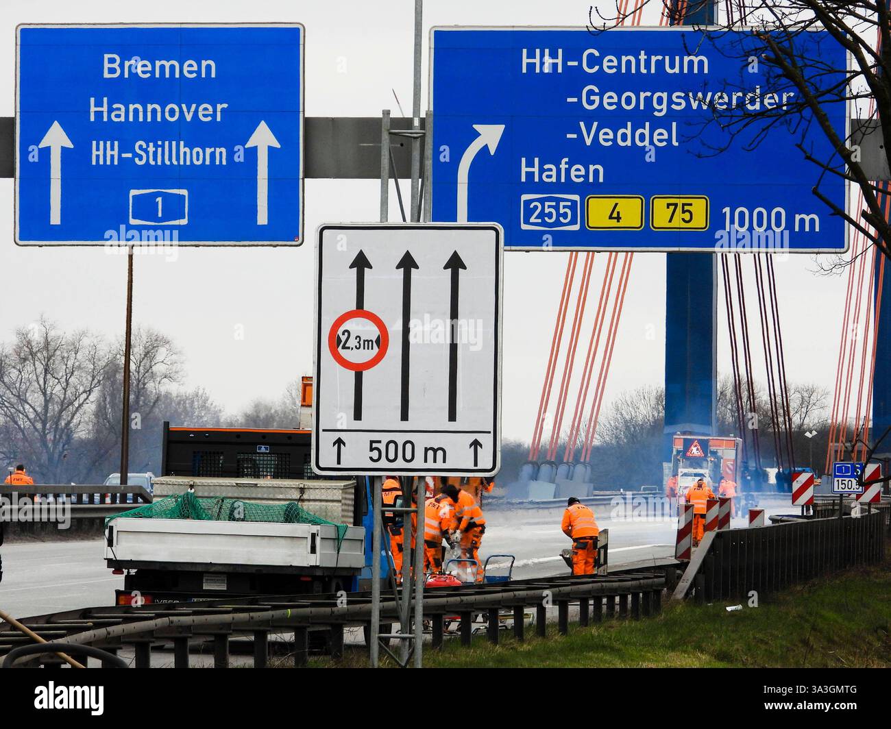 Strassenbauatbeiter der Firma FTM in Orangener Schutzkleidung bringen ...