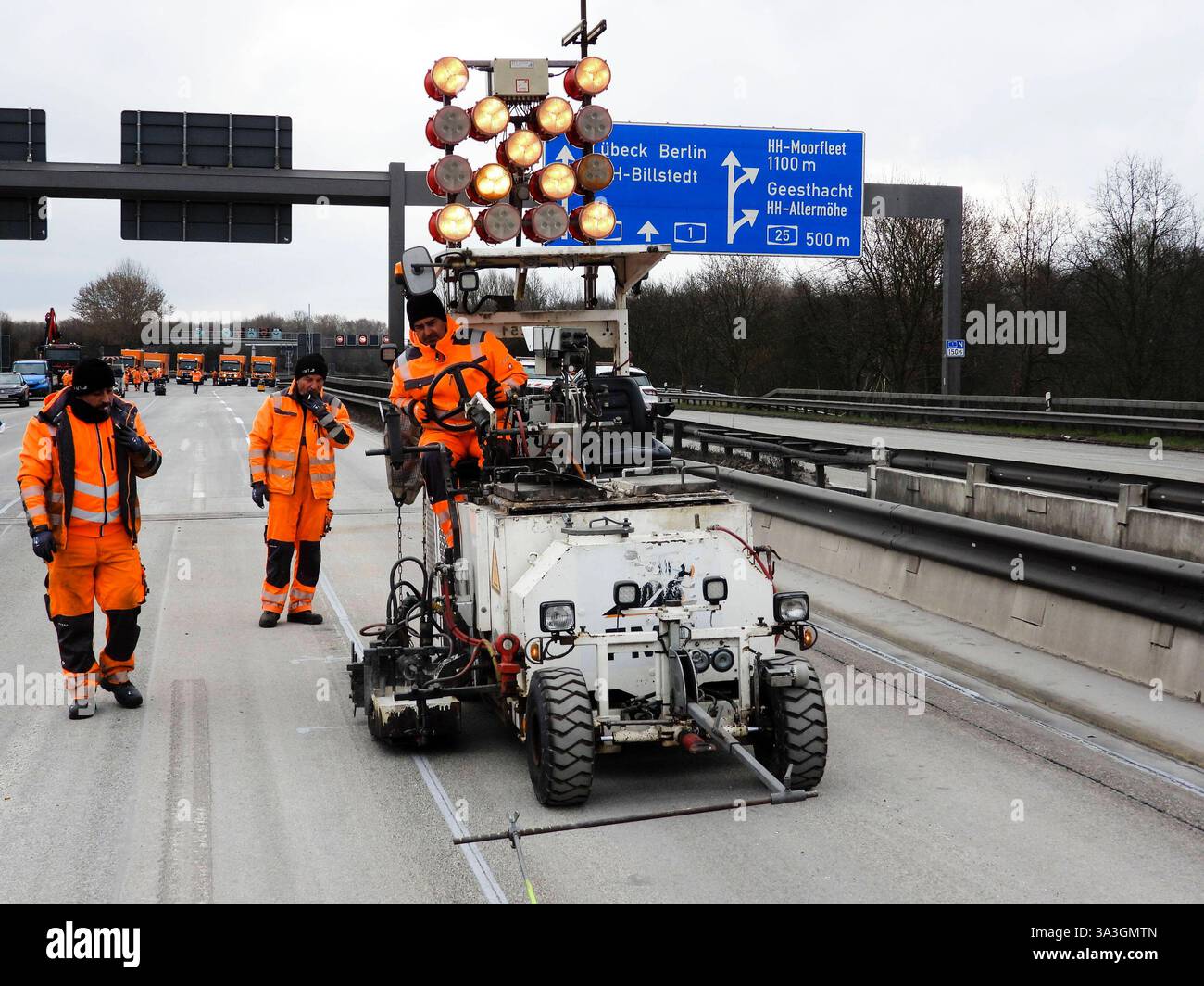 Strassenbauatbeiter der Firma FTM in Orangener Schutzkleidung bringen ...