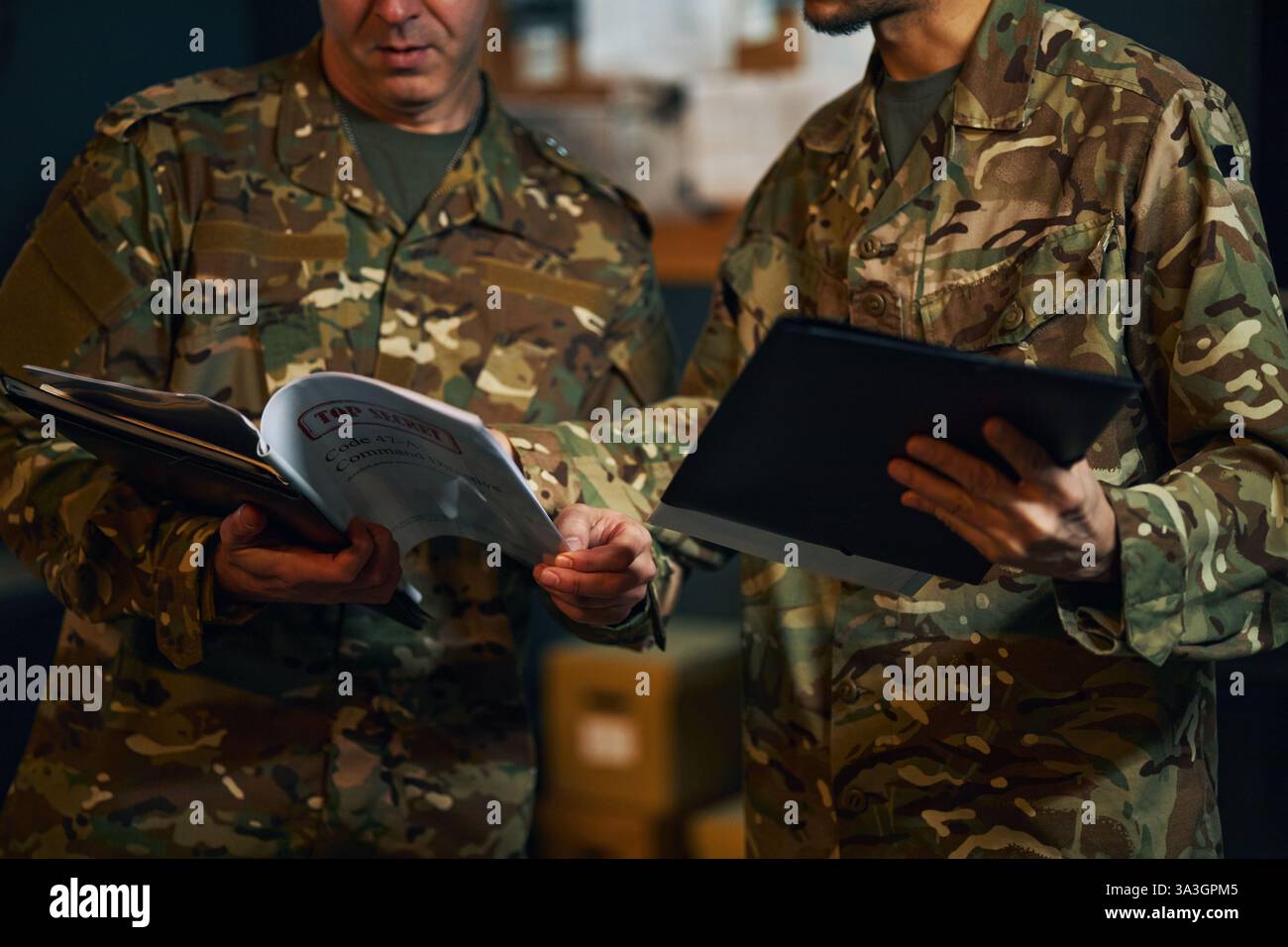 Discussing Military Strategies in Camouflage Uniforms Stock Photo - Alamy