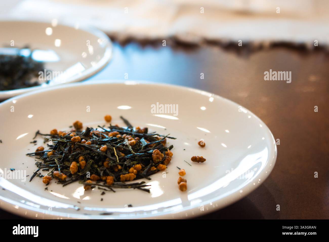Dried green tea leaves on white plate. Japanese dry tea tasting ...
