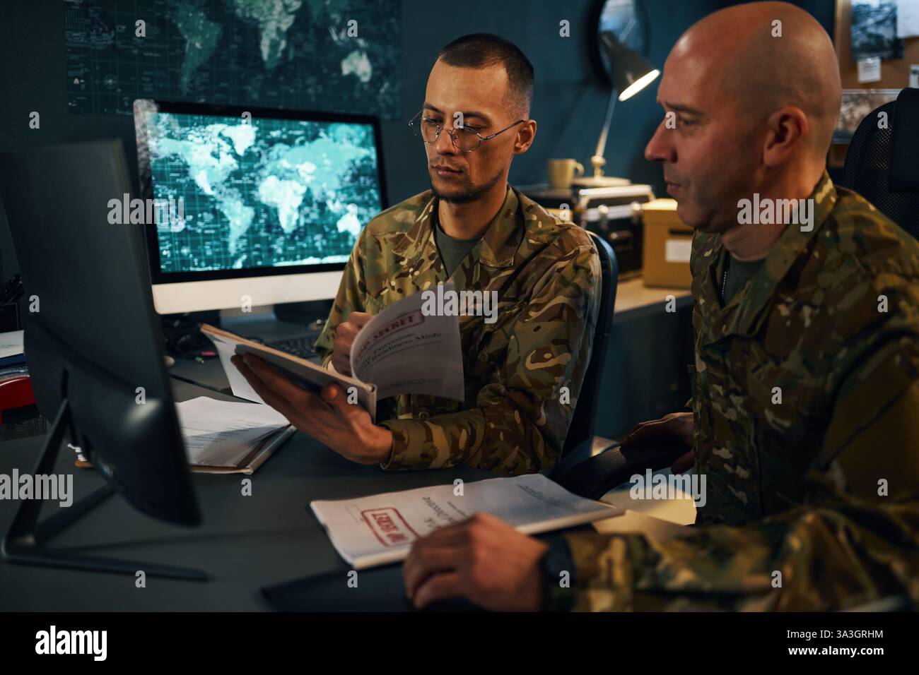 Military Personnel Reviewing Documents at Command Center Stock Photo - Alamy