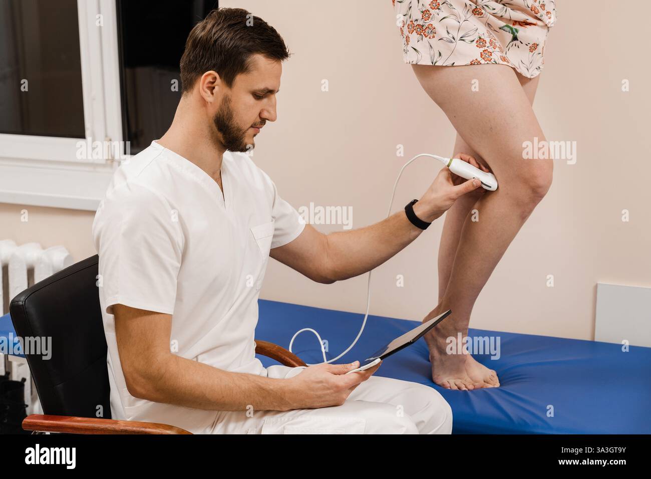 Vascular surgeon examines veins and arteries of legs of girl in medical ...