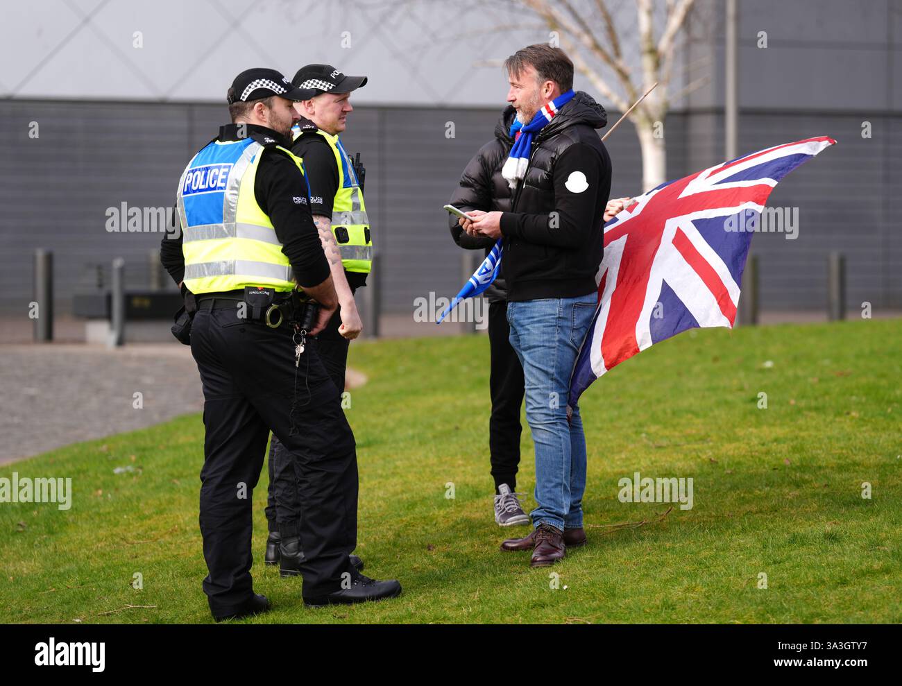 Police officers approach a Rangers fan ahead of the William Hill ...