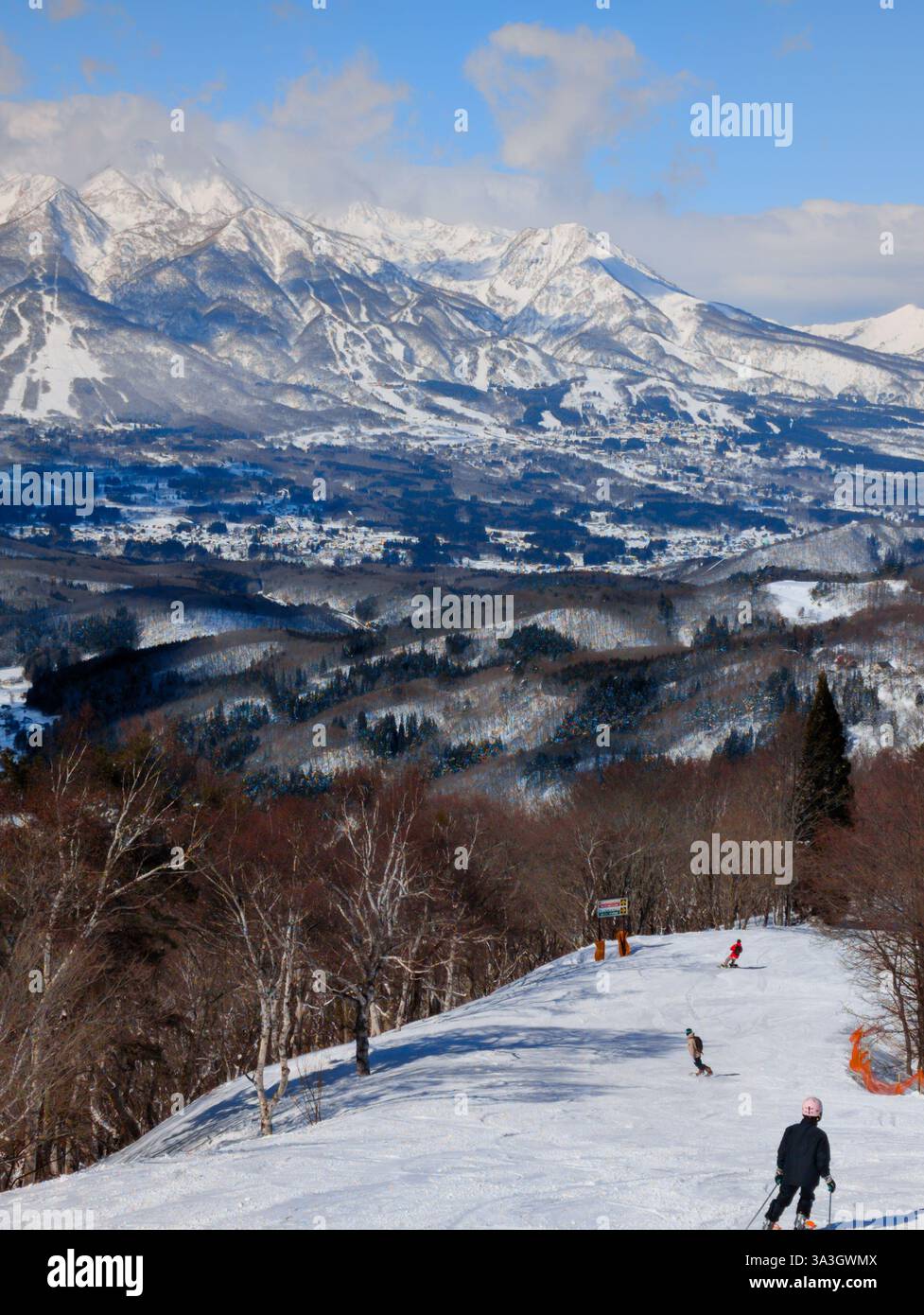 Skiers on ski slope with spectacular mountains in Nagano, Japan Stock ...