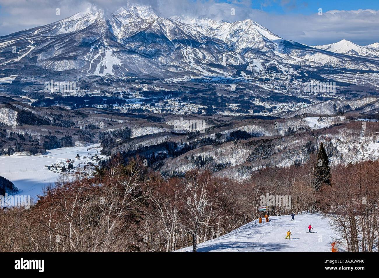 Skiers on ski slope with spectacular mountains in Nagano, Japan Stock ...