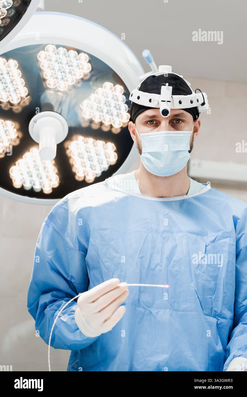 Vascular surgeon is holding EVLT Red laser optical fiber for endovenous ...