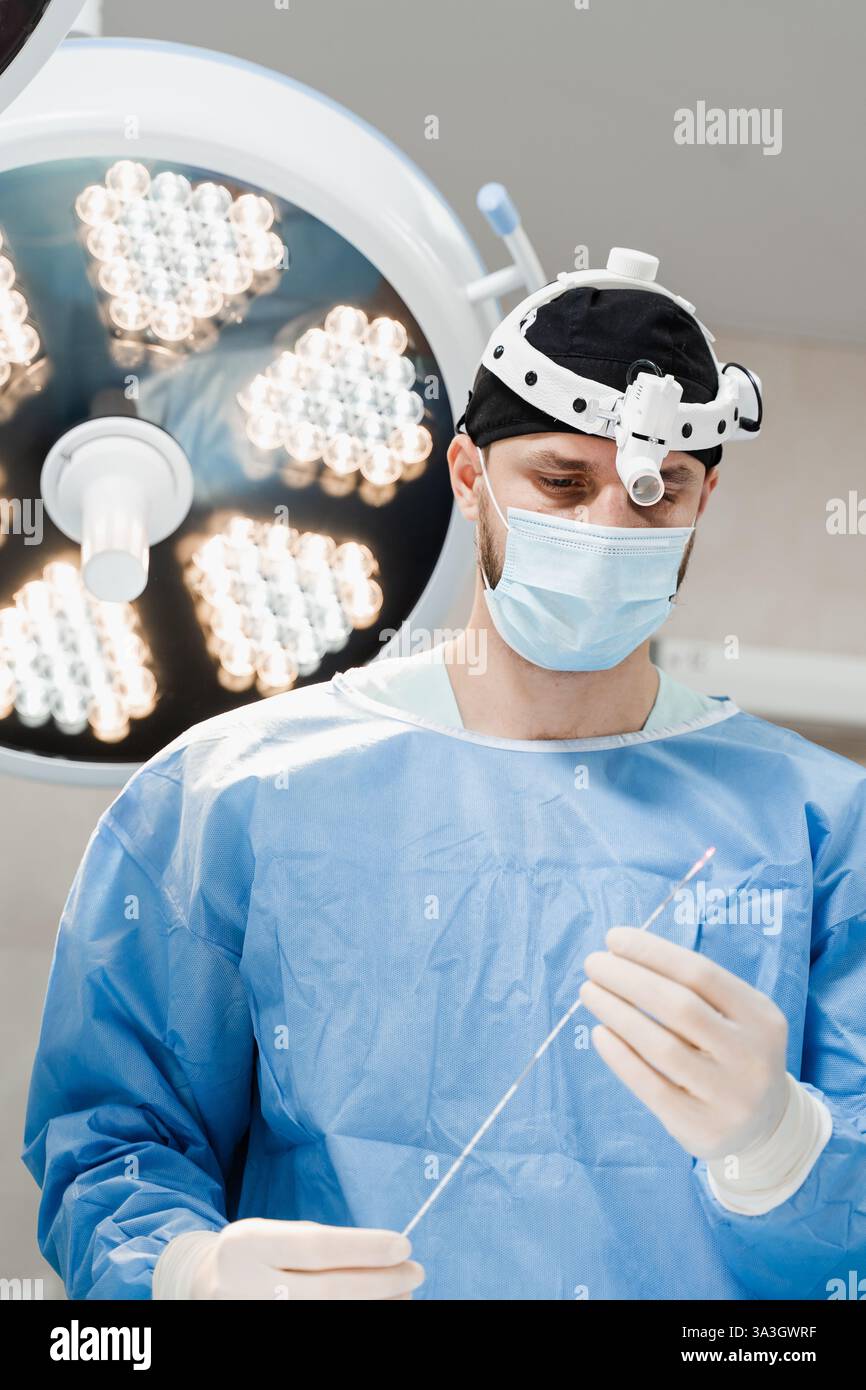 Vascular surgeon is holding EVLT Red laser optical fiber for endovenous ...