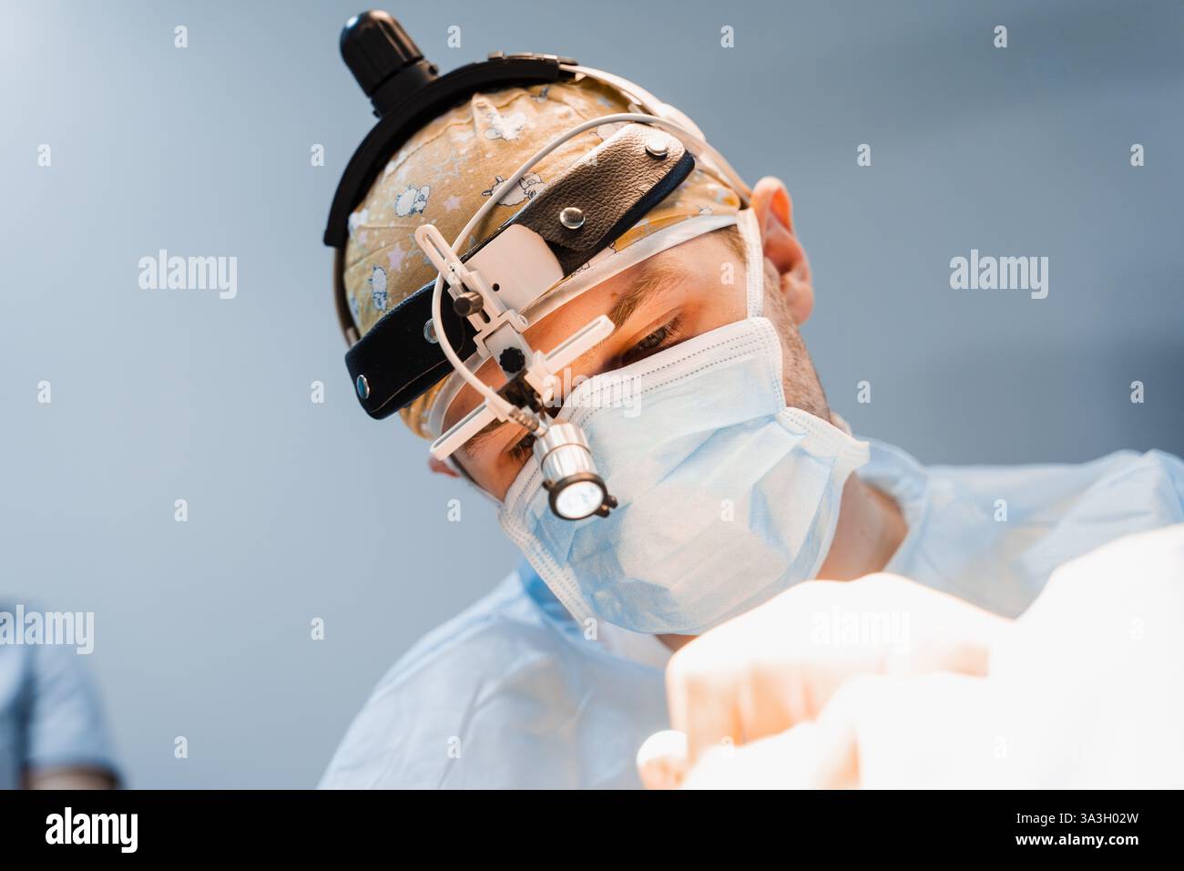 Surgeon with headlight is working in operating room. Blepharoplasty ...