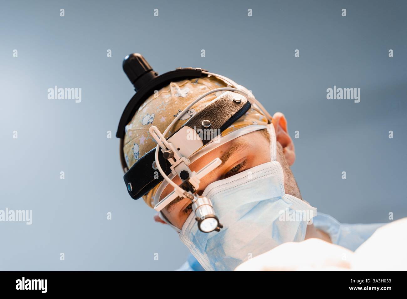Surgeon with headlight is working in operating room. Blepharoplasty ...