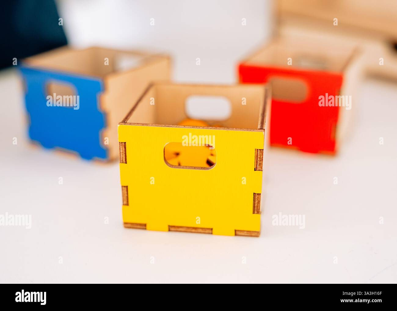 Three boxes: red, yellow and blue with geometric shapes of different ...