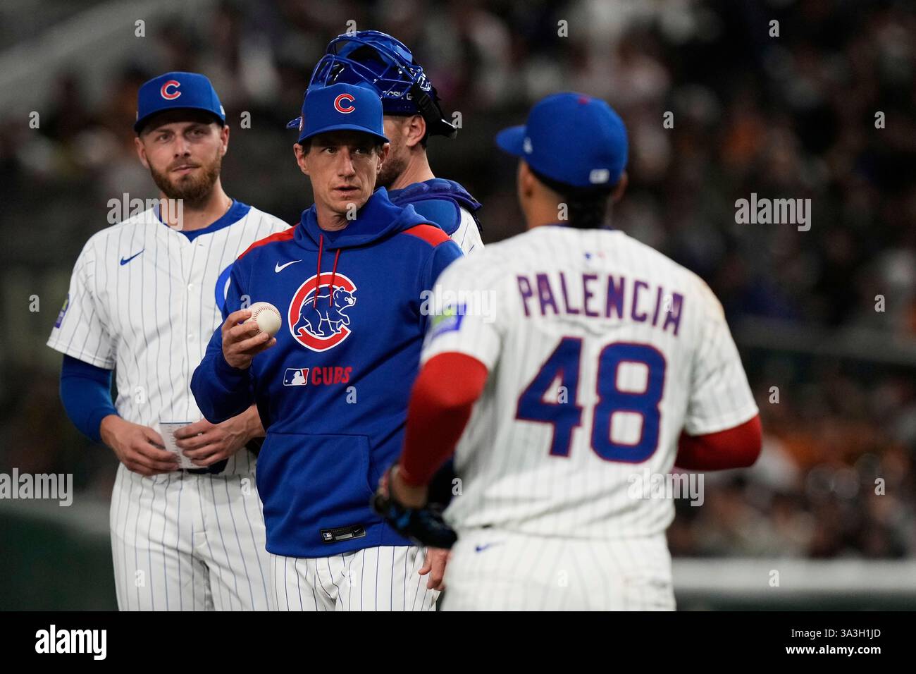 Chicago Cubs manager Craig Counsell, center, turns the ball over to ...