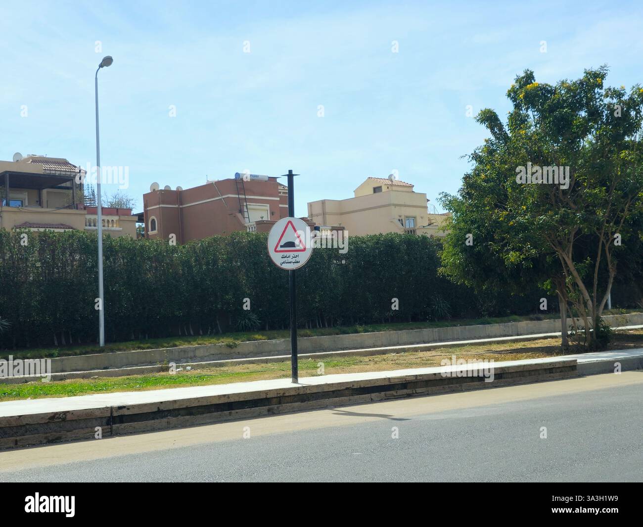 Cairo, Egypt, March 2 2025: Translation of the Arabic text (watch out, a speed bump in front of ...