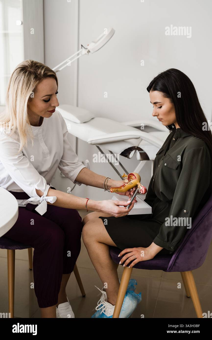 Gynecologist applies uterus model to young woman and explains uterus ...