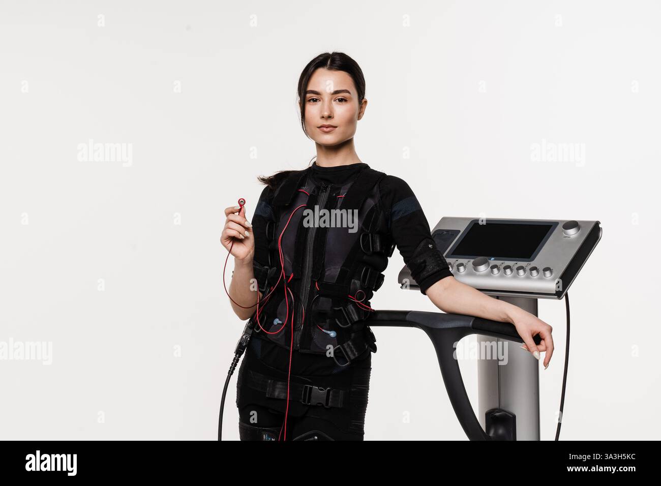 Fit girl in EMS suit with contactor in hand that uses electrical ...