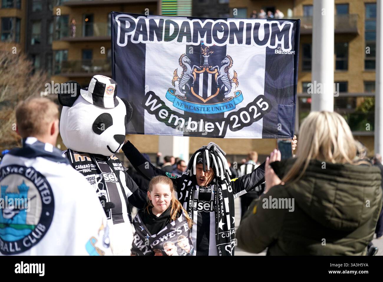 Newcastle United fans pose with a person dressed as a panda outside ...