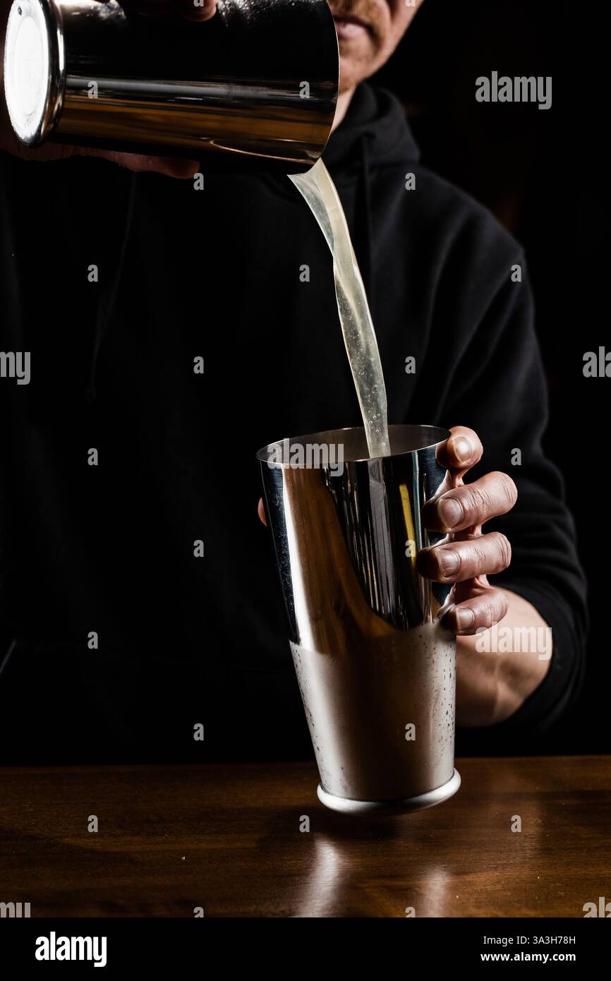 Bartender is pouring and mixing Penicillin cocktail at the bar ...