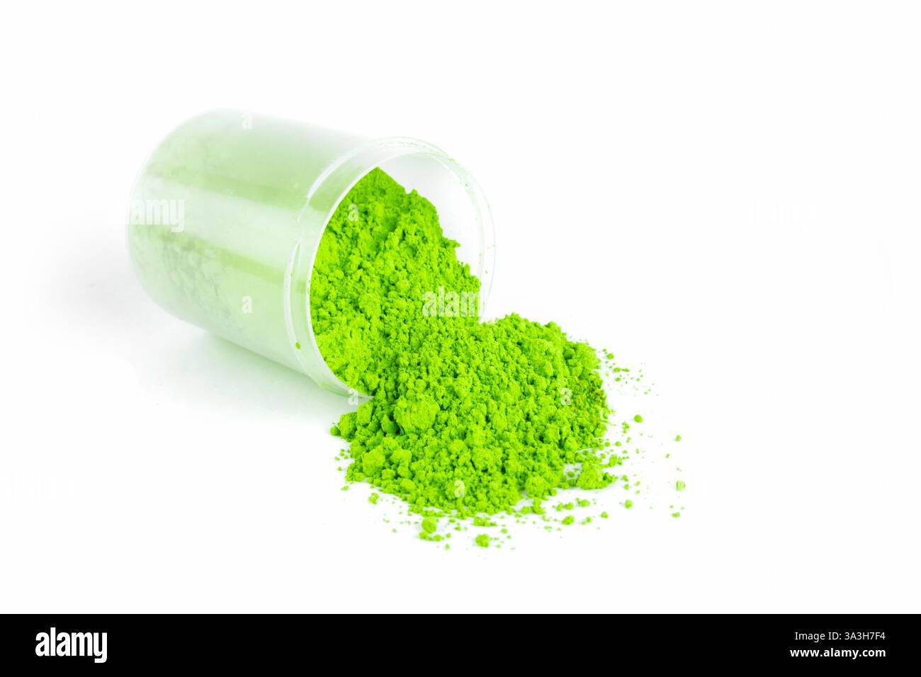 A bright green powder spills from a clear container, contrasting ...