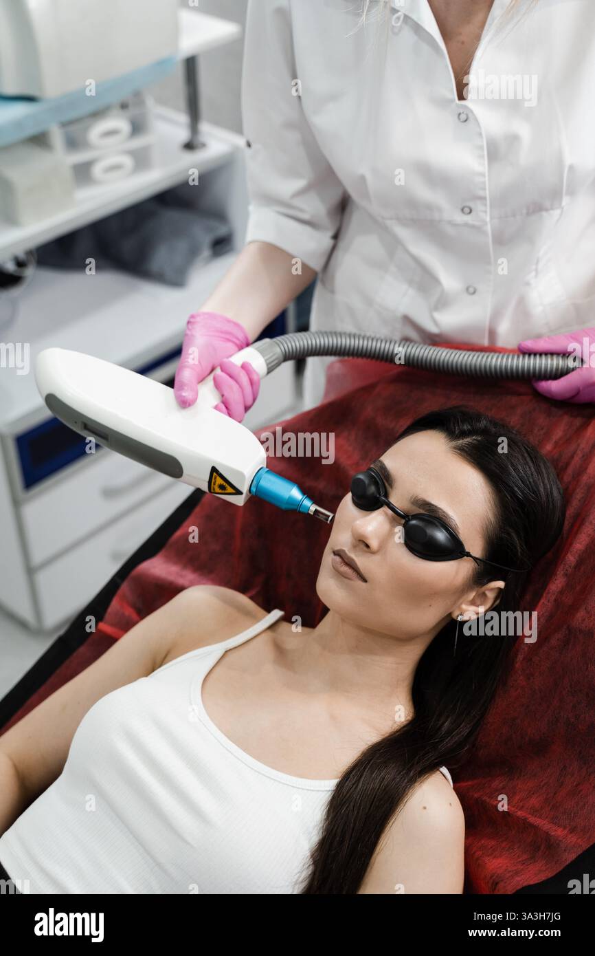 Laser removal of blood vessels on face of girl in dermatological clinic ...