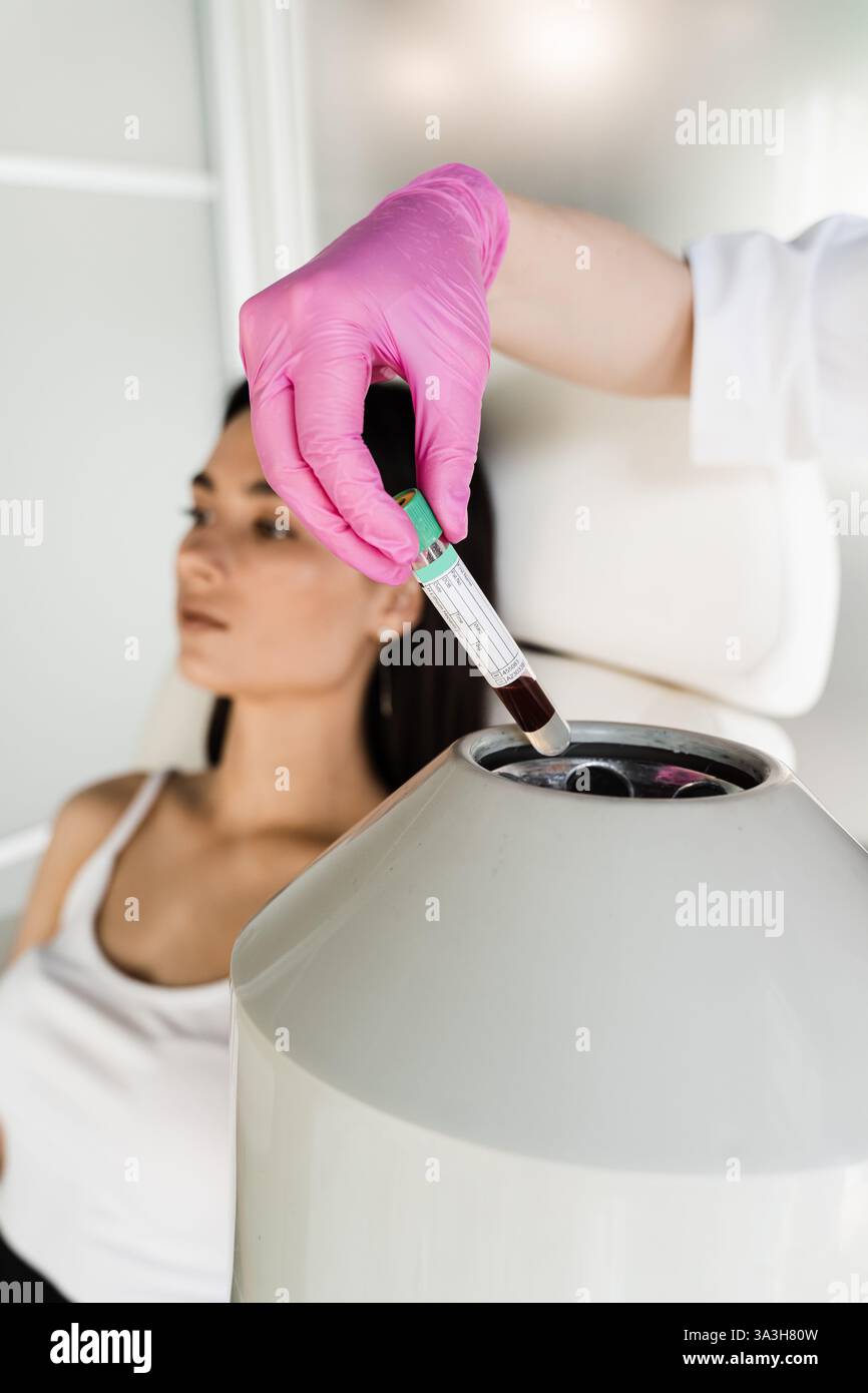 Cosmetologist insert test tube with blood in centrifuge to get plasma ...